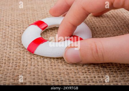 Hand holding a Lifesaver or life preserver on a fabric background Stock ...