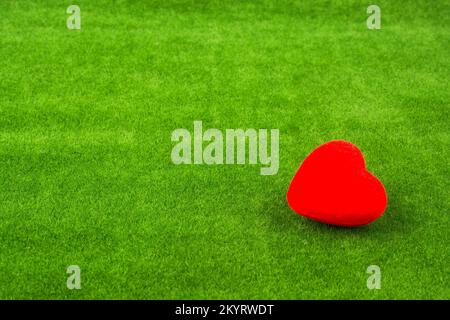 The red heart shape object placed on green grass Stock Photo - Alamy
