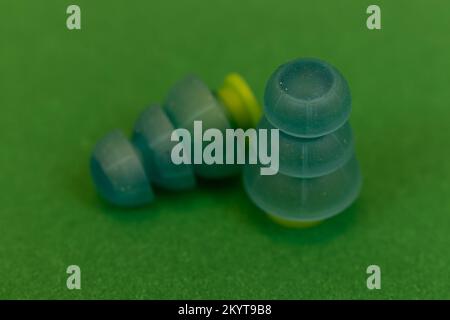 Silicone reusable ear plugs for human ears on green background Stock ...