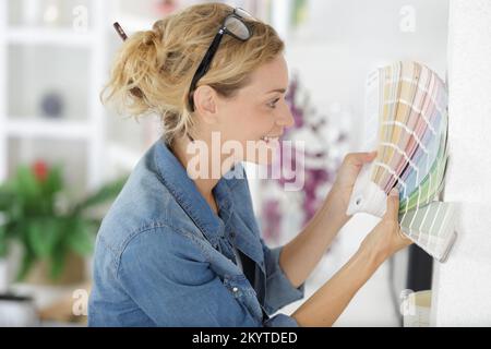 Girl looking at color swatches and choosing between them Stock Photo ...