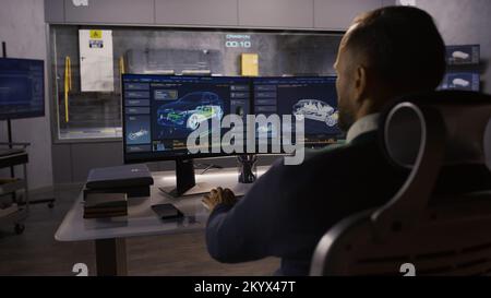 An engineer in a crash test lab uses a car crash test system to ...