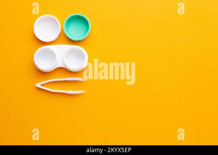 Accessories for contact lenses: a solution container, tweezers. Yellow ...