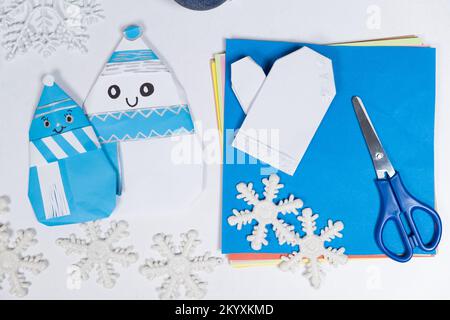 Christmas crafts origami snowman from paper on a background of bokeh ...