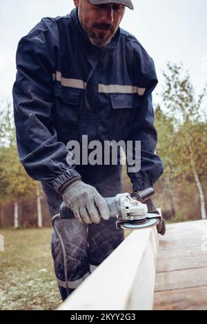 Worker man using electric wheel grinding and cutting on steel structure ...