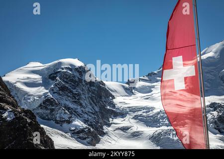 Swiss flag and Bernina mountain range with glaciers in the Alps ...