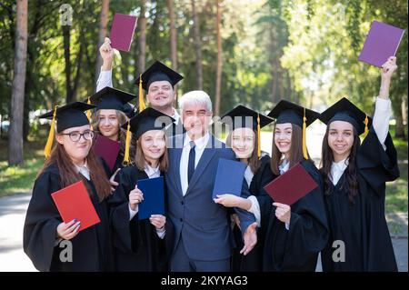 University professor and seven graduates rejoice at graduation Stock ...