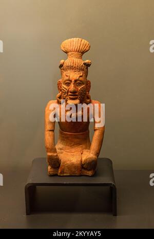 Mayan ceramic figure depicting a sitting woman wearing ear flares and ...