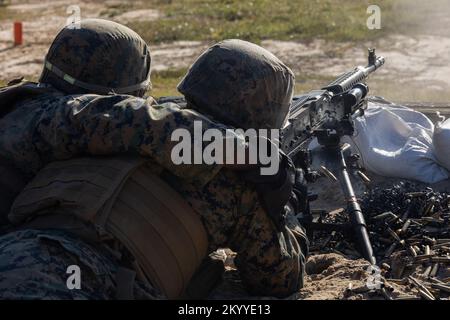 A Marine machine gunner and his assistant are in position to defend ...