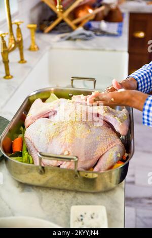 Africa American Woman preparing a large raw turkey for a family ...