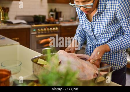 Africa American Woman preparing a large raw turkey for a family ...