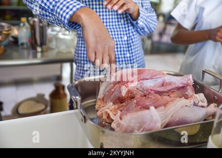 Africa American Woman preparing a large raw turkey for a family ...