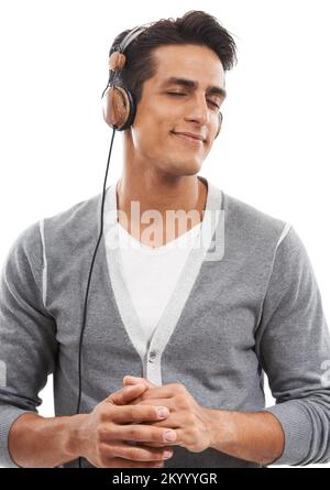He loves his music. A handsome young man listen to music on his mp3 ...