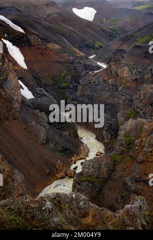 River in a gorge, foot of Asgardsa, volcanic landscape with black and ...
