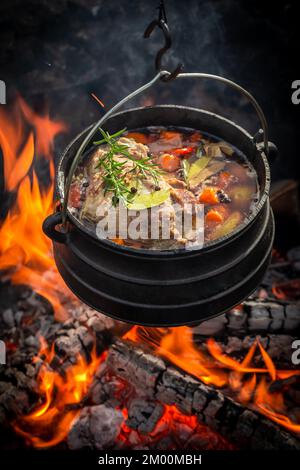 Delicious and hot hunter's stew on bonfire. Hunting stew on the fire ...