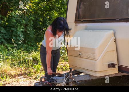 A woman applies the handbrake to a caravan Stock Photo - Alamy