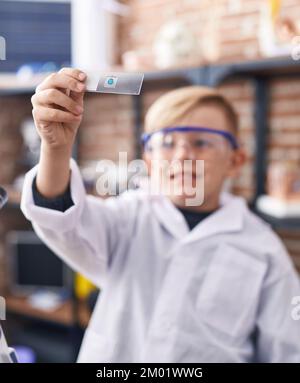 Adorable toddler scientist smiling confident looking sample at ...
