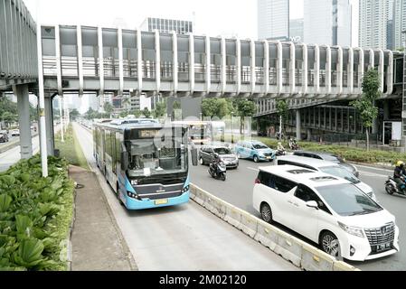 Trans Jakarta bus in bus way line, at the rush hour traffic. Location in business district ...