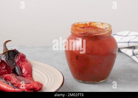 Glass jar of delicious Ljutenica made of roasted bell peppers on ...