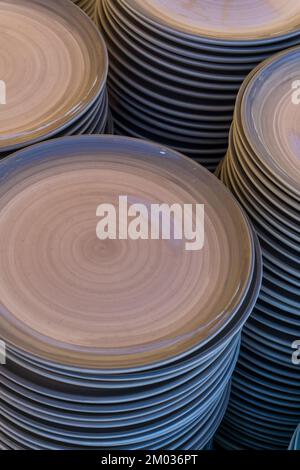 Handmade painted and glazed pottery stacked on display in a shop in old ...
