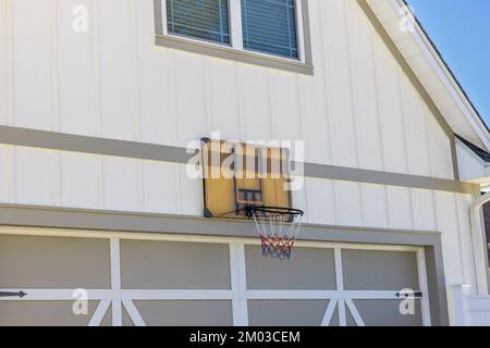 A basketball hoop mounted outside and above the garage of a new ...