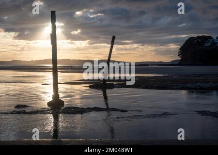 Poles marking river mouth channel for boats entering the river, Orewa ...