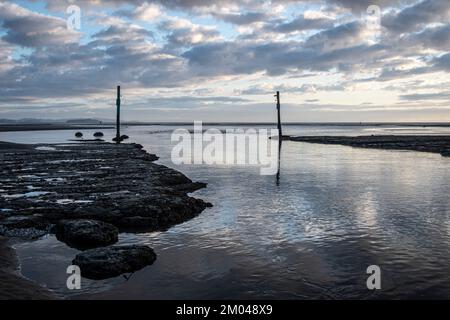 Poles marking river mouth channel for boats entering the river, Orewa ...