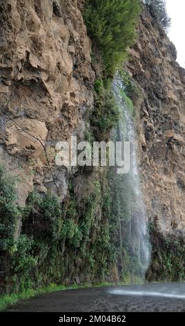small waterfall drops on to a street on madeira island Stock Photo - Alamy