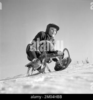 Winter in the 1950s. A boy on his sledge ready to go downhill. Sweden ...