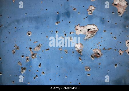 Holes from artillery shell fragments in the wall of an apartment ...