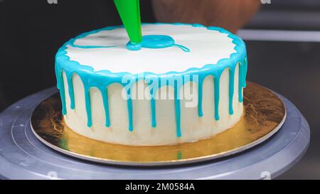 bag piping filling topping on frosted icing drip turquoise cake for ...
