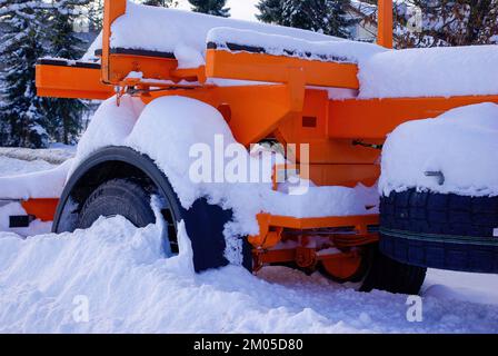 Snow-covered low loader or articulated lorry with a wheel stuck in the ...