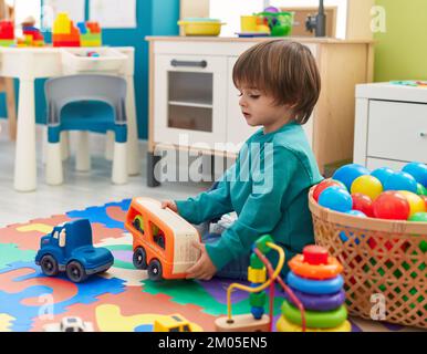 Adorable toddler playing with truck toy standing at kindergarten Stock ...