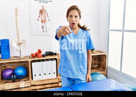 Middle age hispanic physiotherapist woman working at pain recovery ...