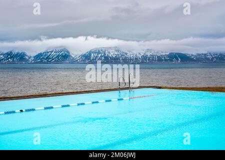 Outdoor swimming pool, Hofsos, Trollaskagi Skagafjord, mountain range ...