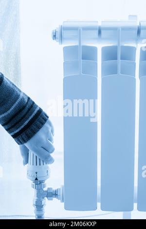 Radiator adjustment closeup. Female hand adjusting radiator temperature ...