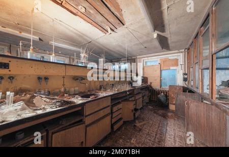 Old abandoned chemical laboratory. Long table with broken flasks Stock ...