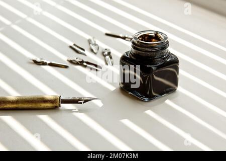 Inkpot with metal tips for the ink pen on a white background in solar ...