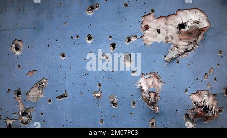 Holes from artillery shell fragments in the wall of an apartment ...