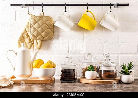 Interior of stylish kitchen with dinnerware, jars of pasta and utensils ...