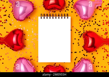 Empty notepad mockup and inflatable foil balloon on a pink glittering ...