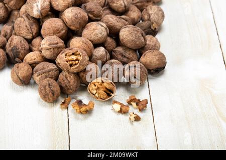 Stacked walnuts from basket on white wooden table - walnut harvest ...