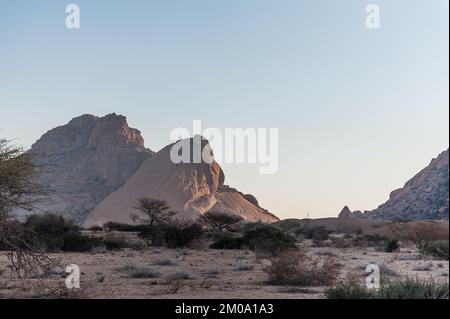 Bold rock formations glowing bright orange in the last rays of the ...
