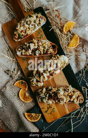 Delicious bruschetta with mushrooms on cutting board on table close-up ...