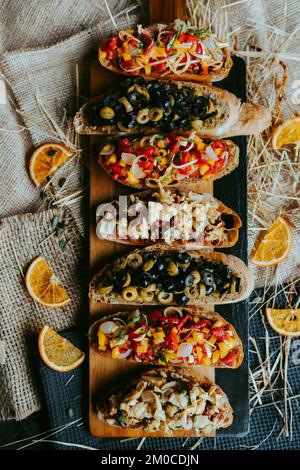 A vertical shot of bruschetta set with vegetables, mushrooms, and ...
