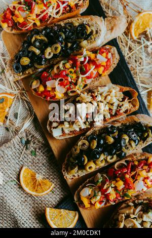 A vertical shot of bruschetta set with vegetables, mushrooms, and ...