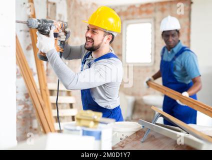 Two builders working on indoor construction site Stock Photo - Alamy