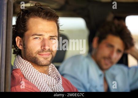 On the road again. Two friends driving together while on a road trip ...