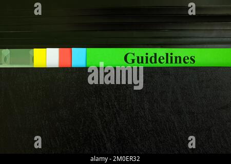 Hand picking guidelines file record in black binder folder. Work ...