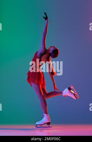 Winter sports. One junior female figure skater in red stage costume ...
