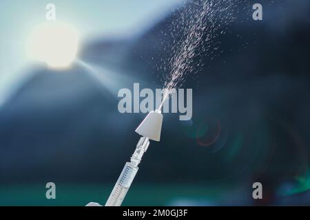 Hand using a syringe with a mucosal atomization decive (MAD) for ...